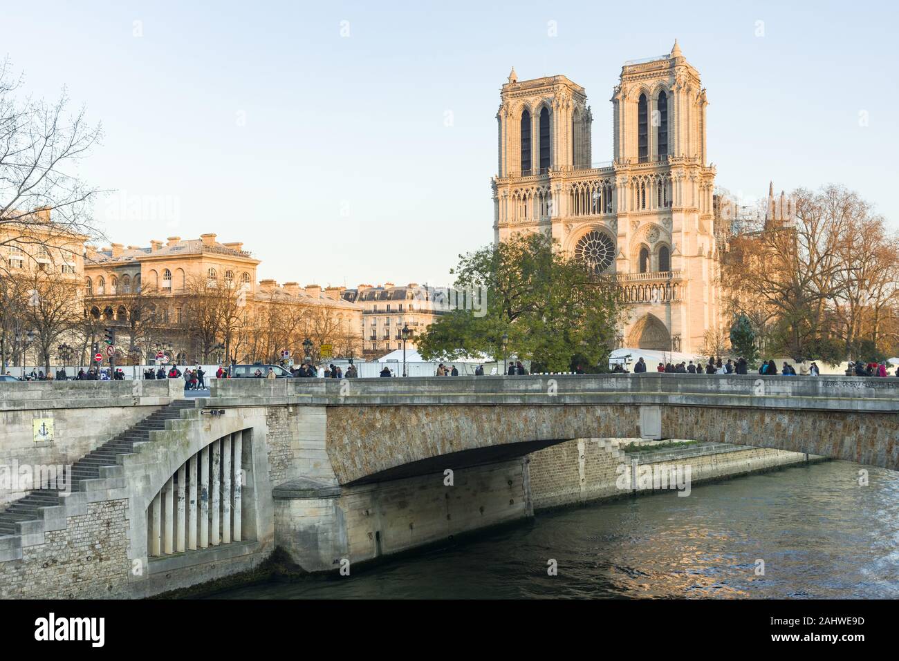 Tourists on stone bridge taking photographs of Notre-Dame cathedral ...