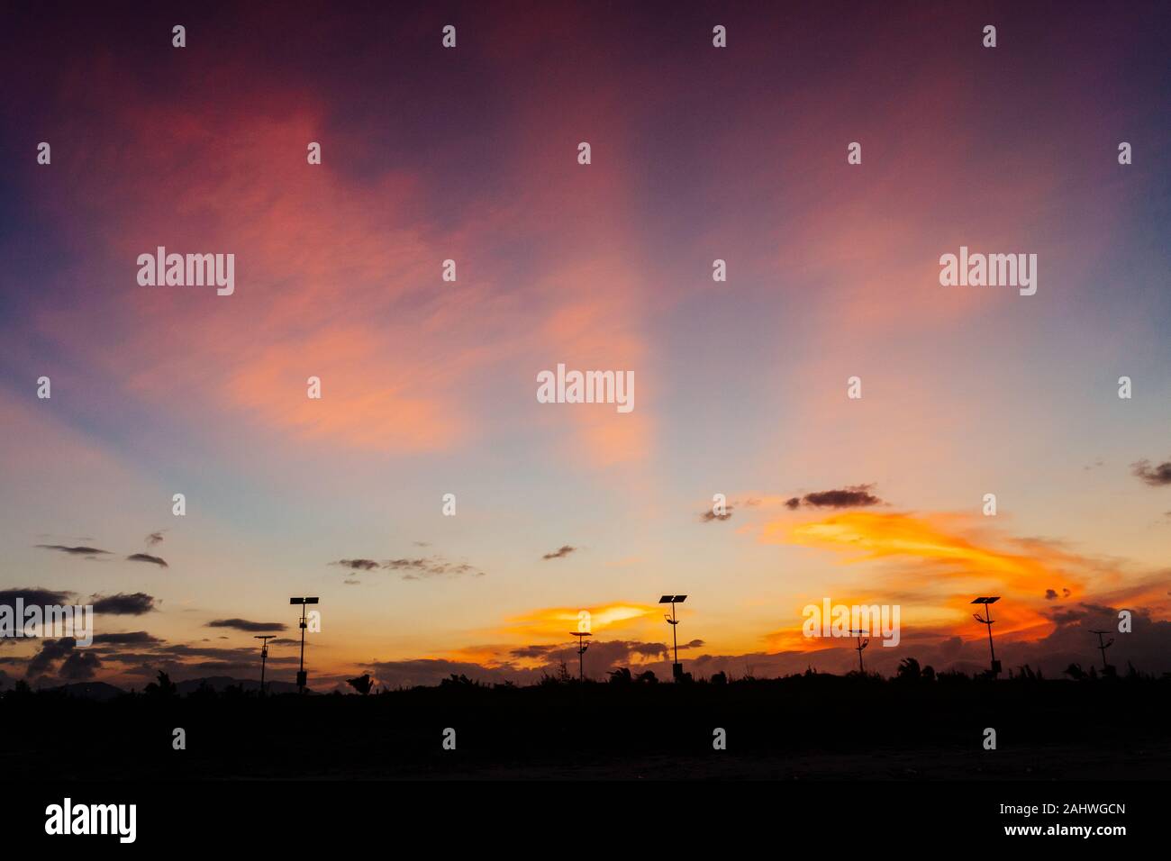 Dramatic sunset sky. Bright colors of sun going down. Sunlight rays shining from behind clouds ...