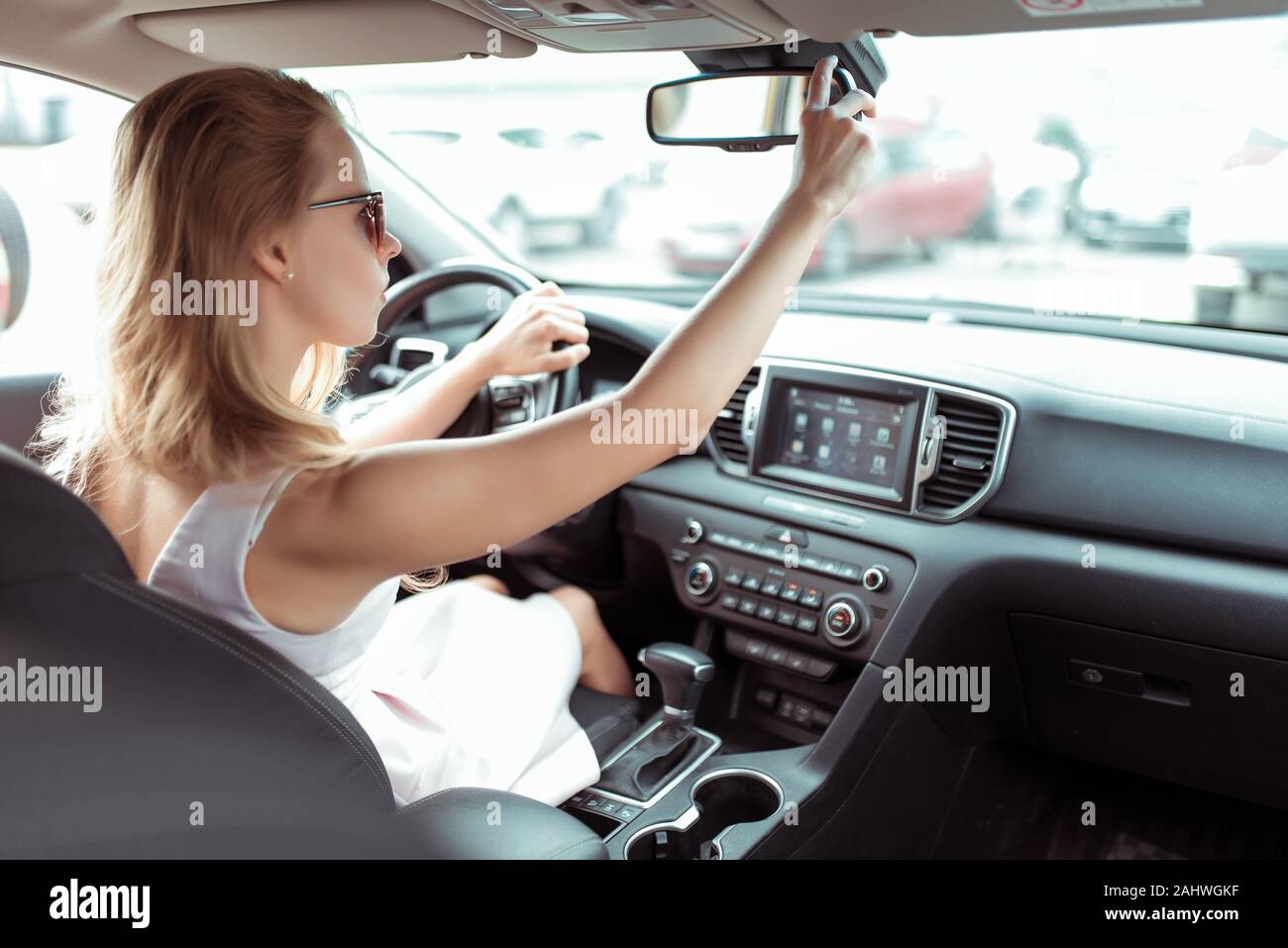 woman in car, adjusts and rearview mirror, driving safety in car ...
