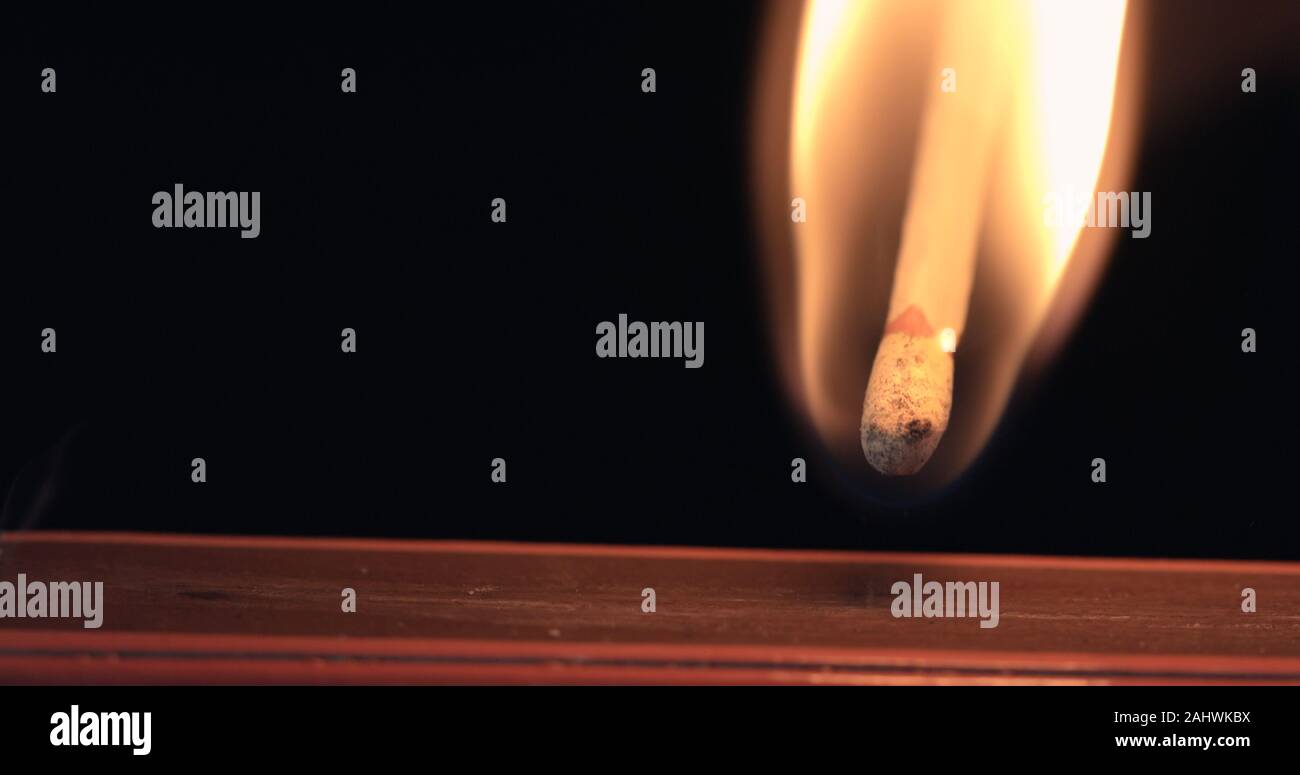 Firing up matches. Ignition lose-up detail of on matchbox and showing ...