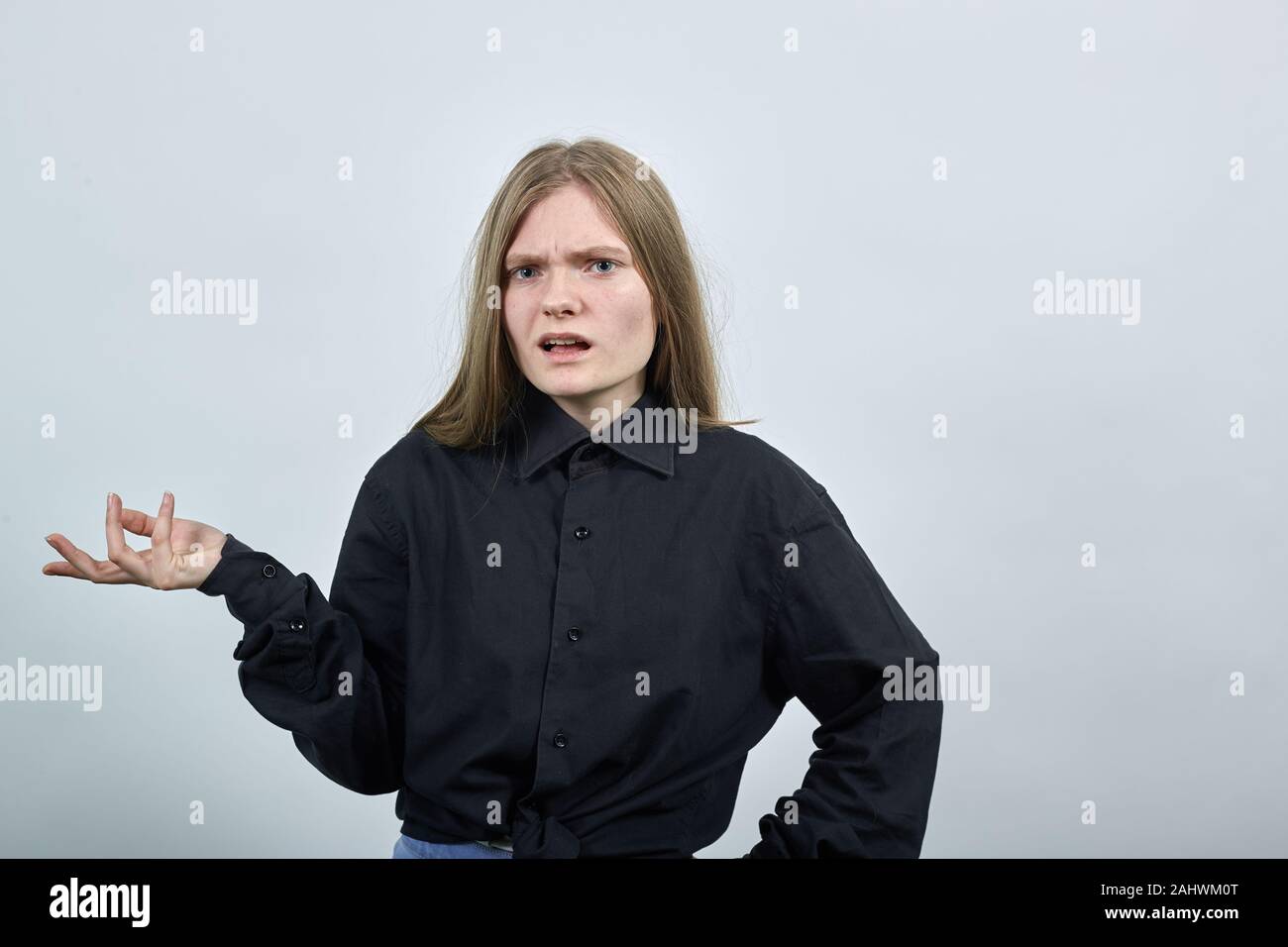 Disappointed woman spread hand, keeping hand on belt, looking confused ...