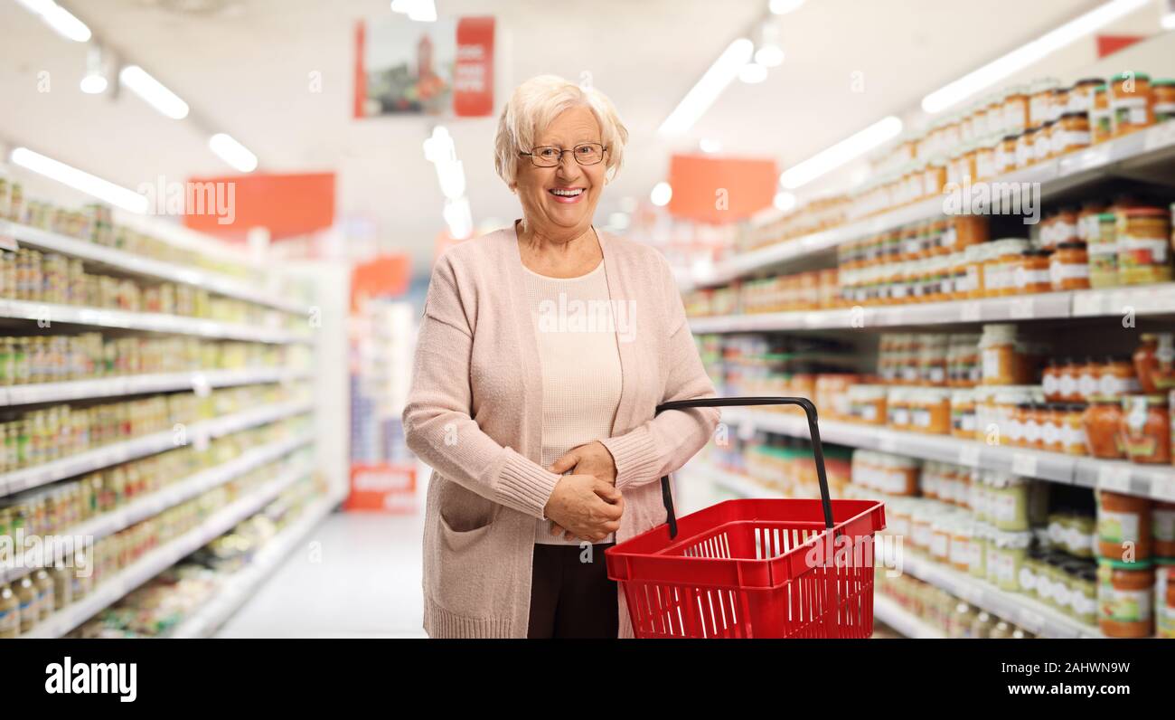 Senior female customer with a shopping basket in a supermarket Stock ...