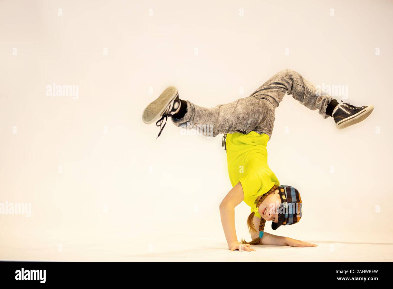 girl in a unique dance position, breakdance kid, a little girl performs ...