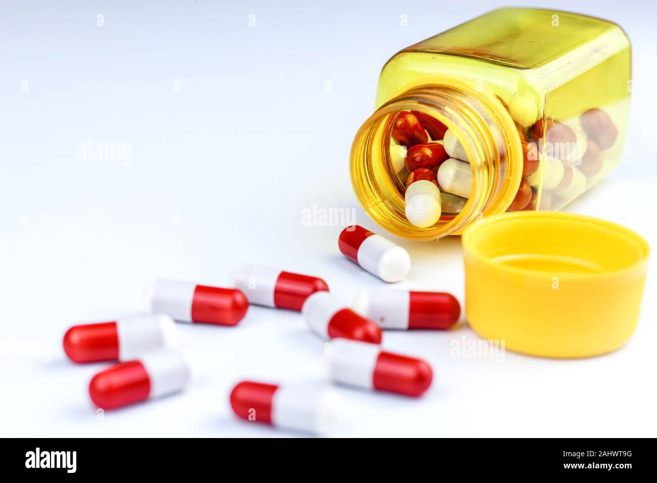 Red-white tablets on white background. Medicines in yellow jar ...