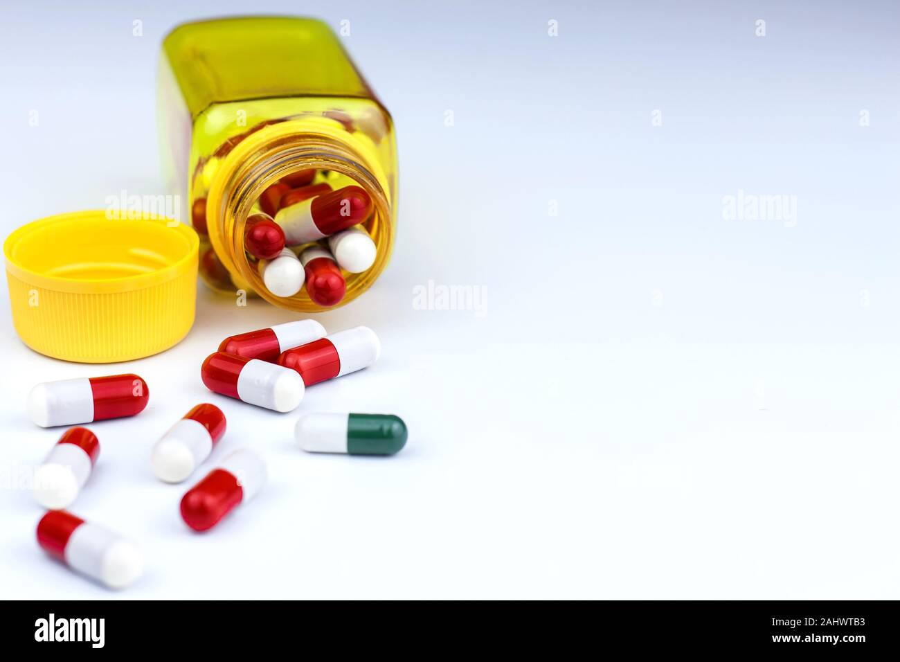 Red-white tablets on white background. Medicines in yellow jar ...