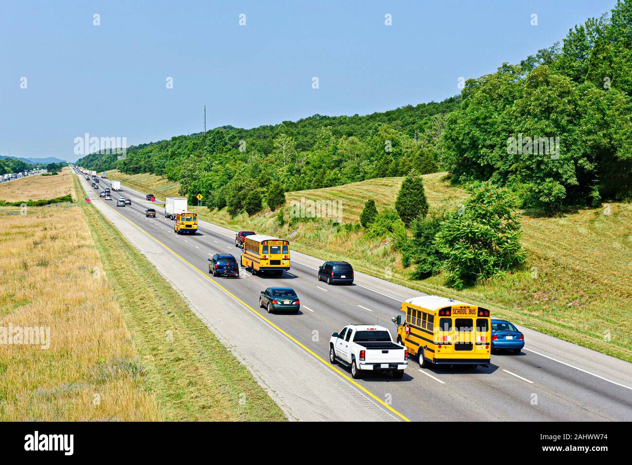Horizontal shot of yellow school buses on an interstate highway Stock ...