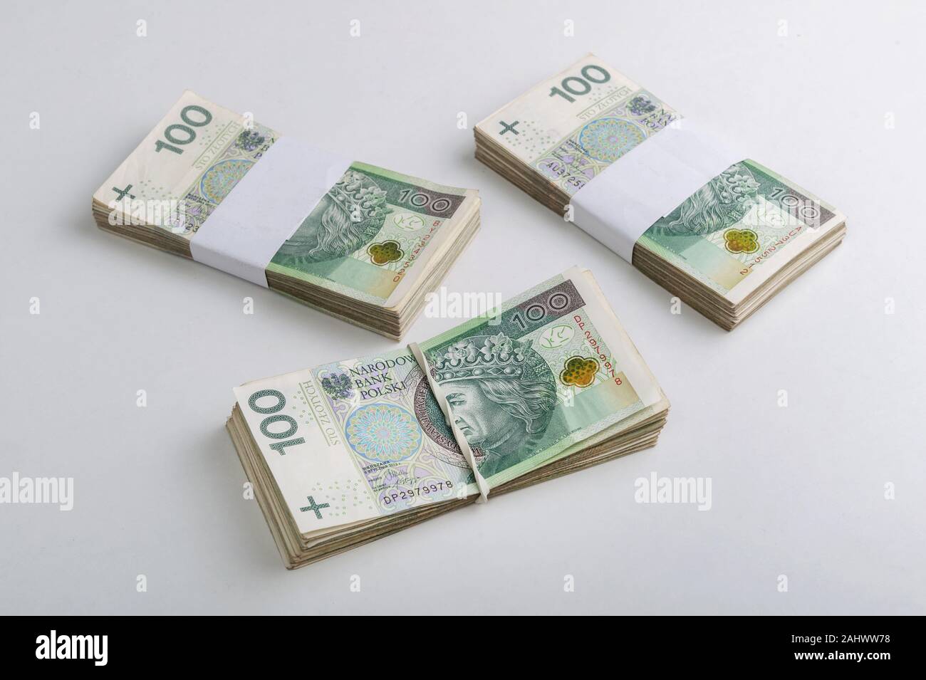 Piles of one hundred polish zloty (PLN) banknotes on white background ...