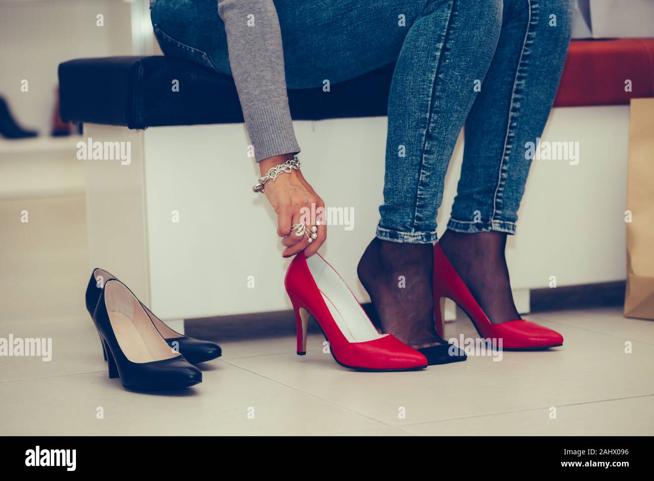 Woman doing some shopping and trying on a few pairs of high heels at a ...