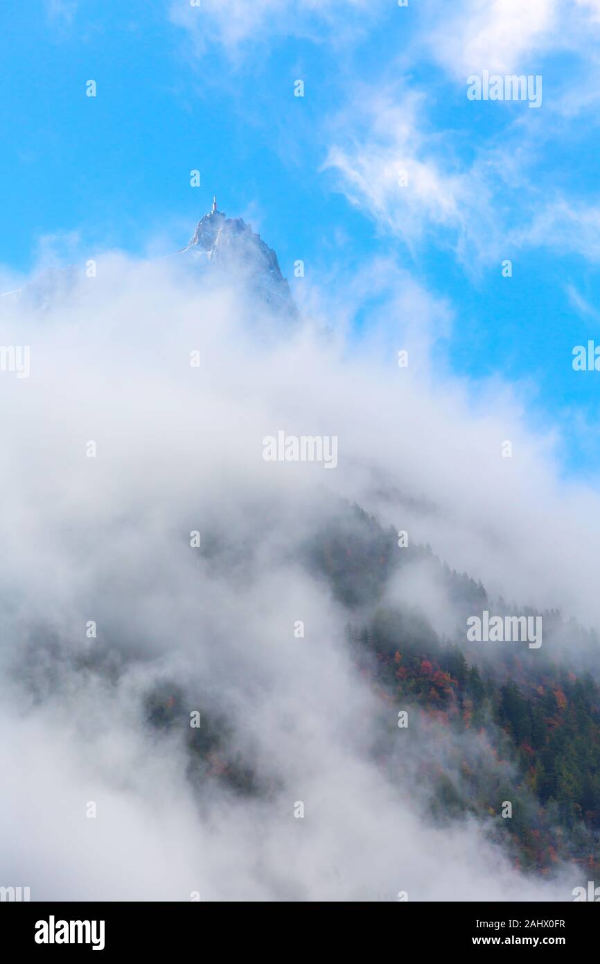 Aiguille du Midi peak between clouds, mountain in the Mont Blanc massif in the French Alps ...
