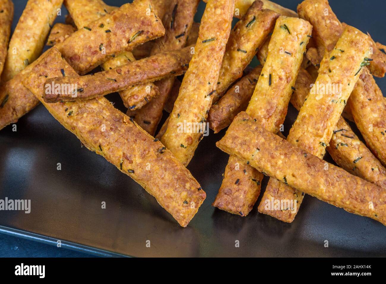 Plate of stacked chive cheese straws, landscape, close up Stock Photo ...