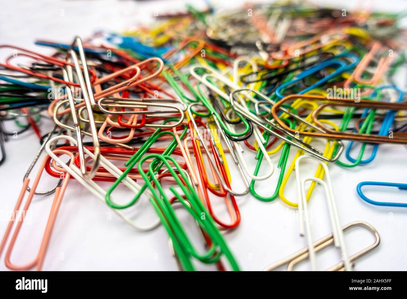 A pile of paper clips against a white background Stock Photo - Alamy