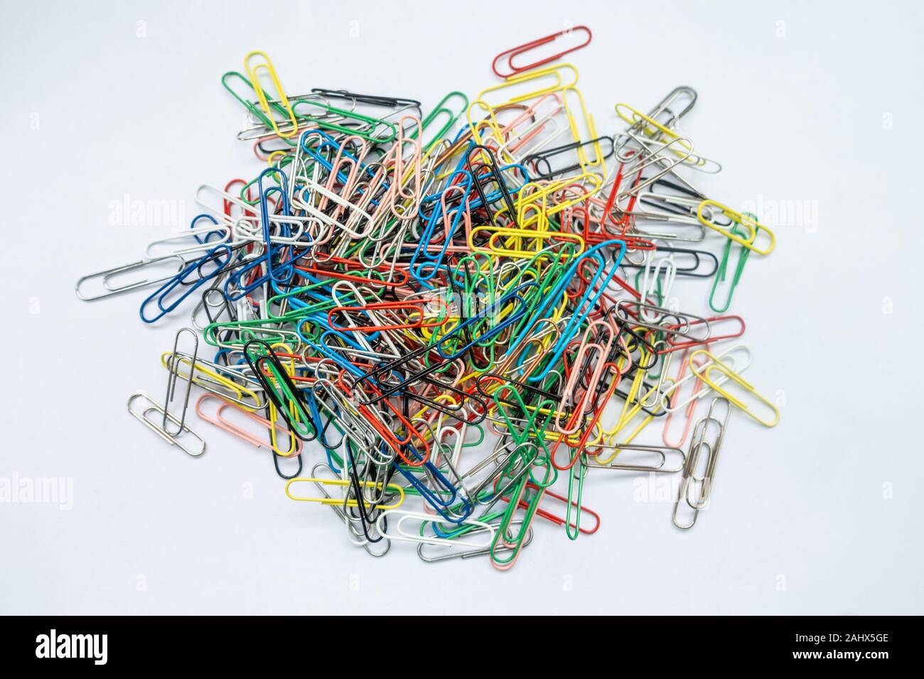 A pile of paper clips against a white background Stock Photo - Alamy
