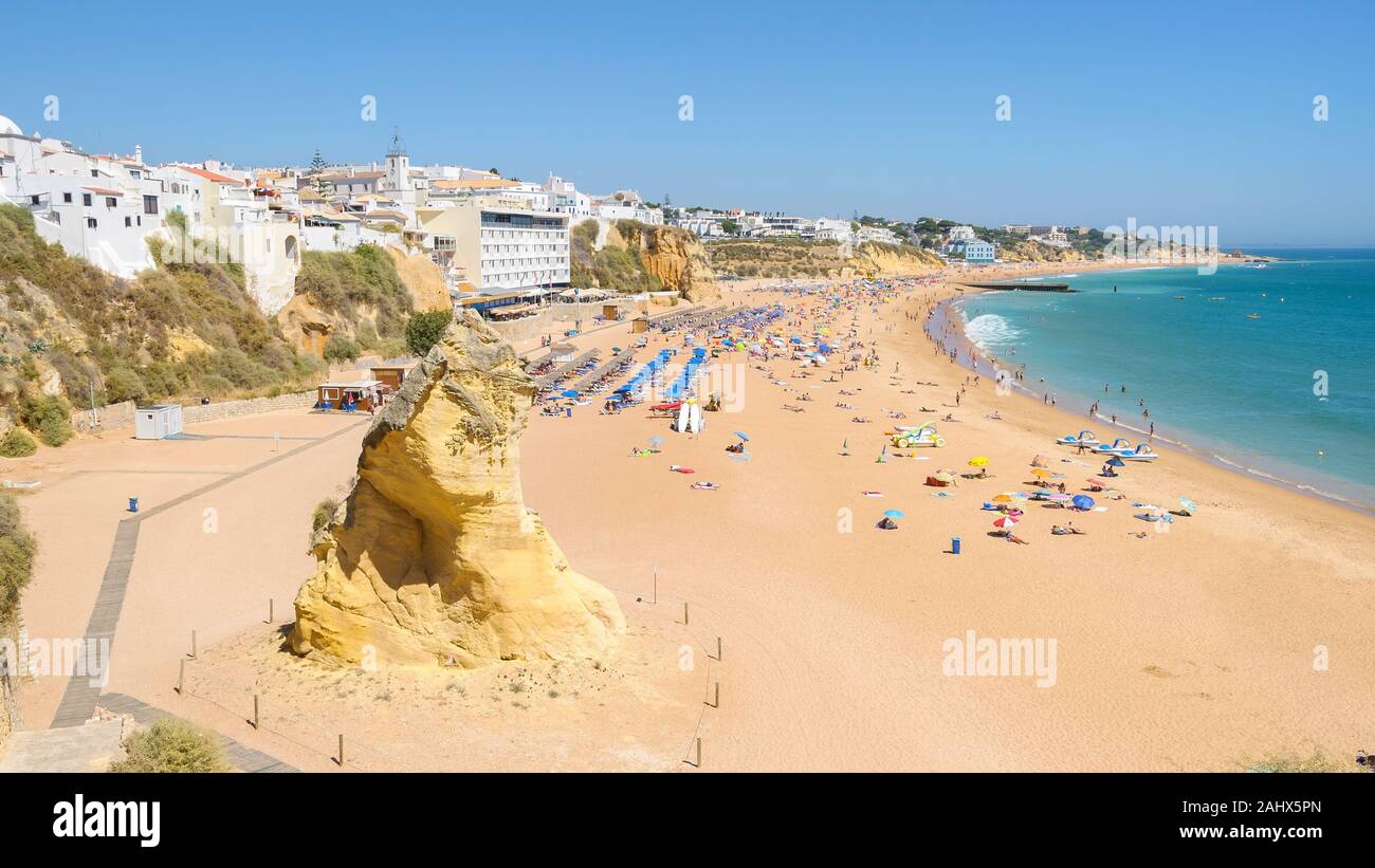 View of sunny public beach with sandstone rock in Albufeira, Algarve ...