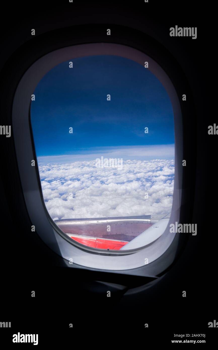 Airplane window with fluffy clouds Stock Photo - Alamy