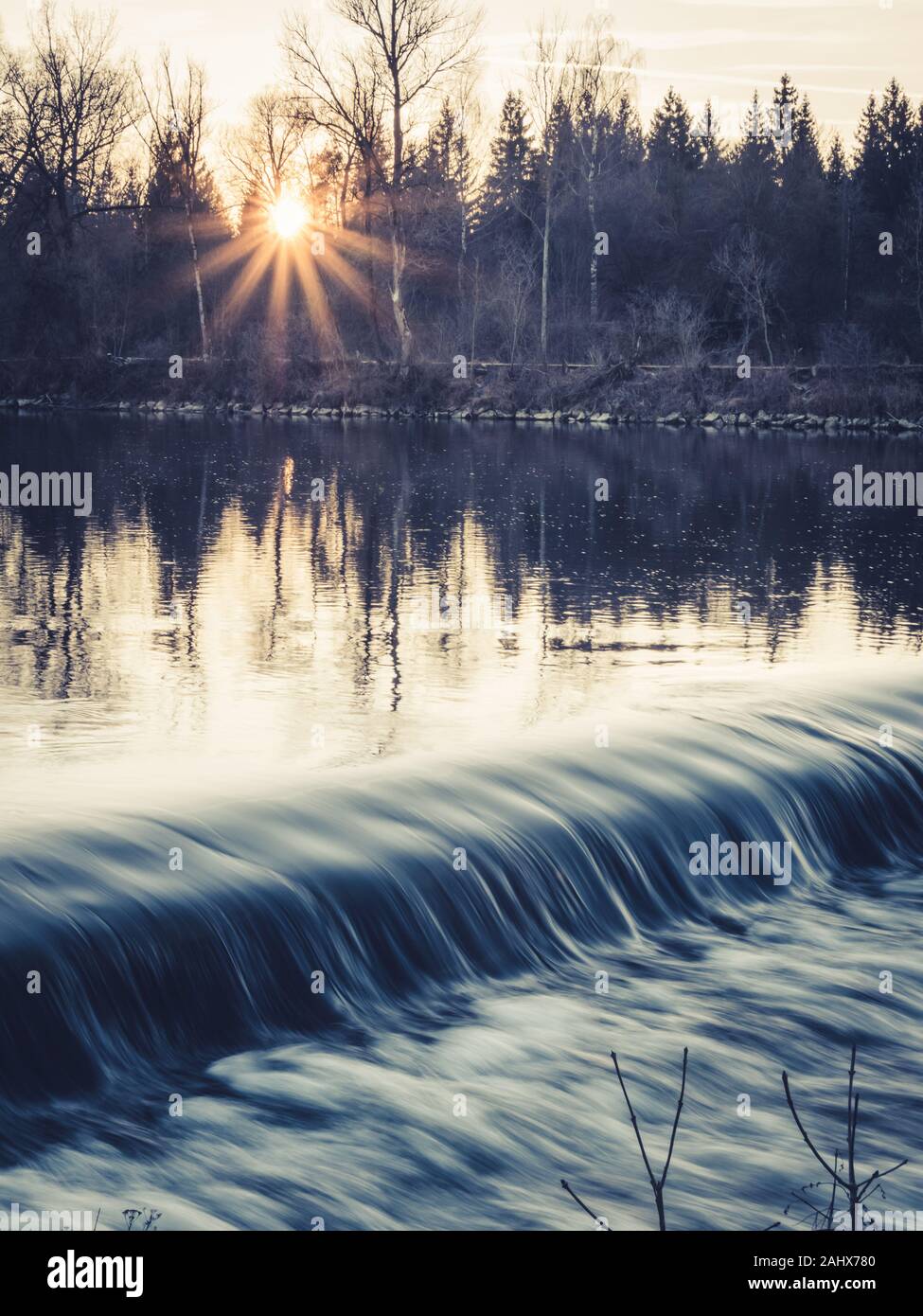 Water flowing over a weir during sunset with sun rays in the winter, Augsburg Stock Photo - Alamy