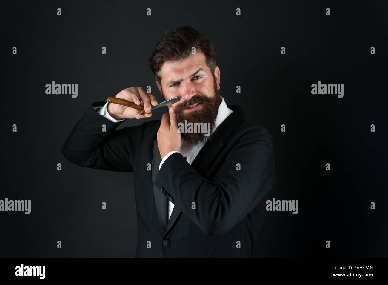 Manual shaving. Bearded man shave facial hair dark background ...