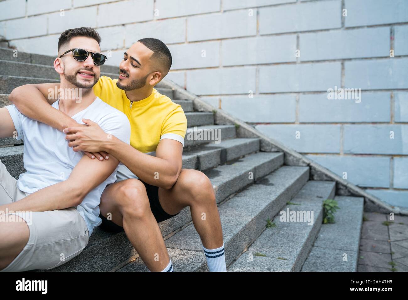 Portrait of happy gay couple spending time together while sitting on ...