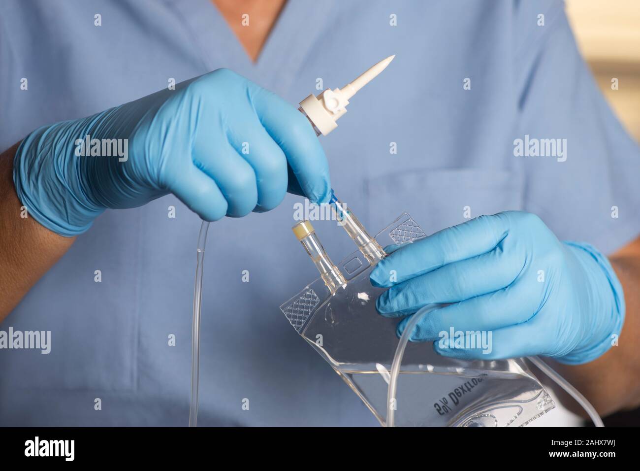 Nurse prepares to spike 5% dextrose solution for IV infusion Stock ...