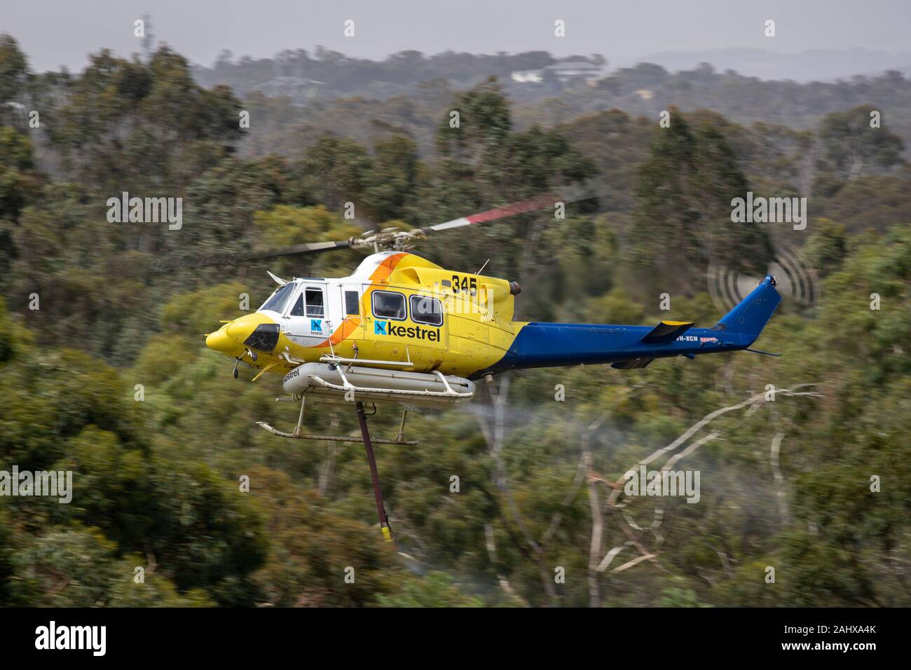 Bell 412 helicopter taking off after filling with a load of water to ...