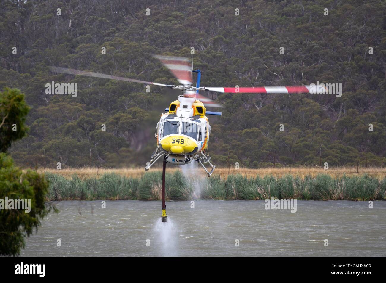 Bell 412 helicopter taking off after filling with a load of water to ...