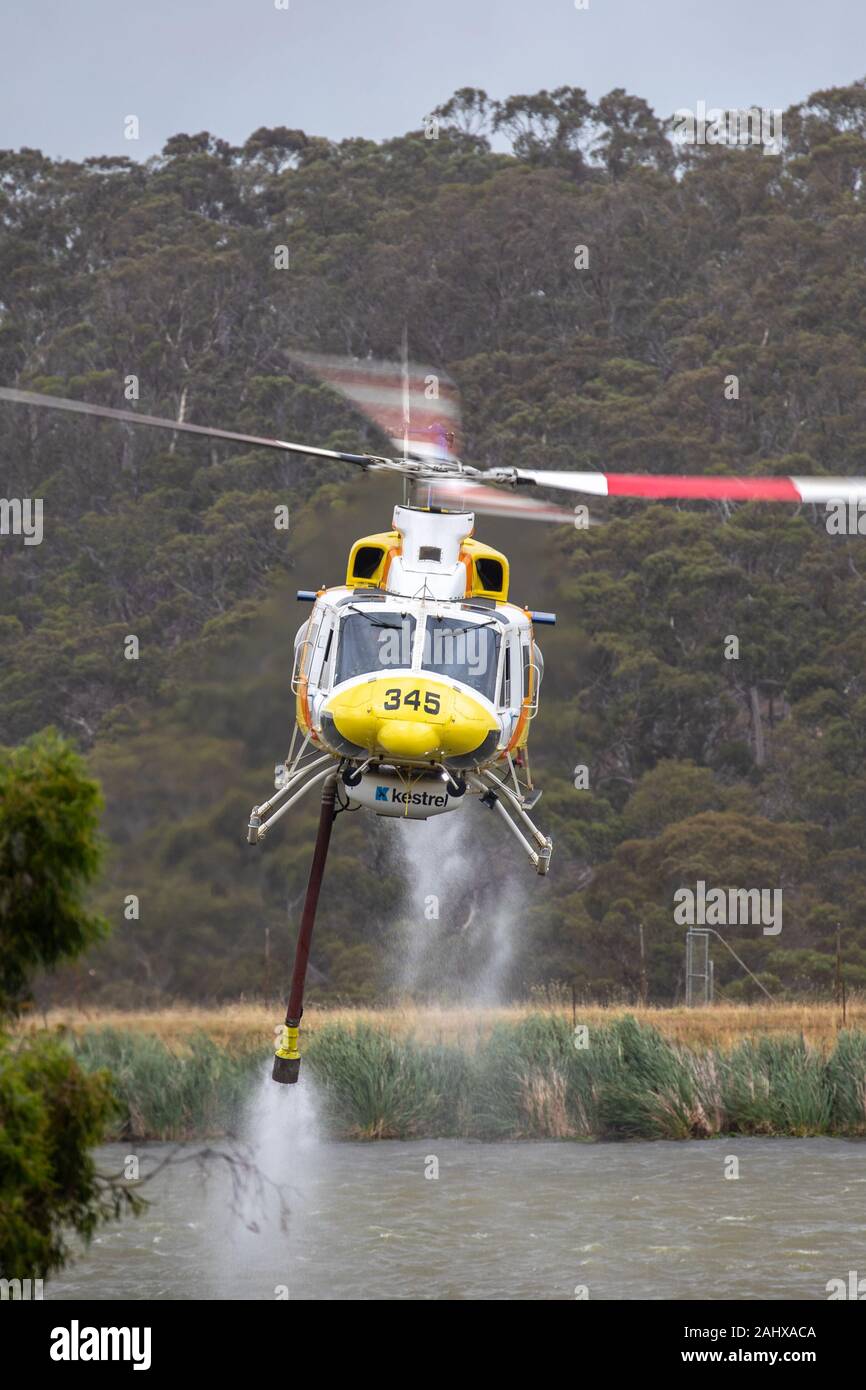 Bell 412 helicopter taking off after filling with a load of water to ...