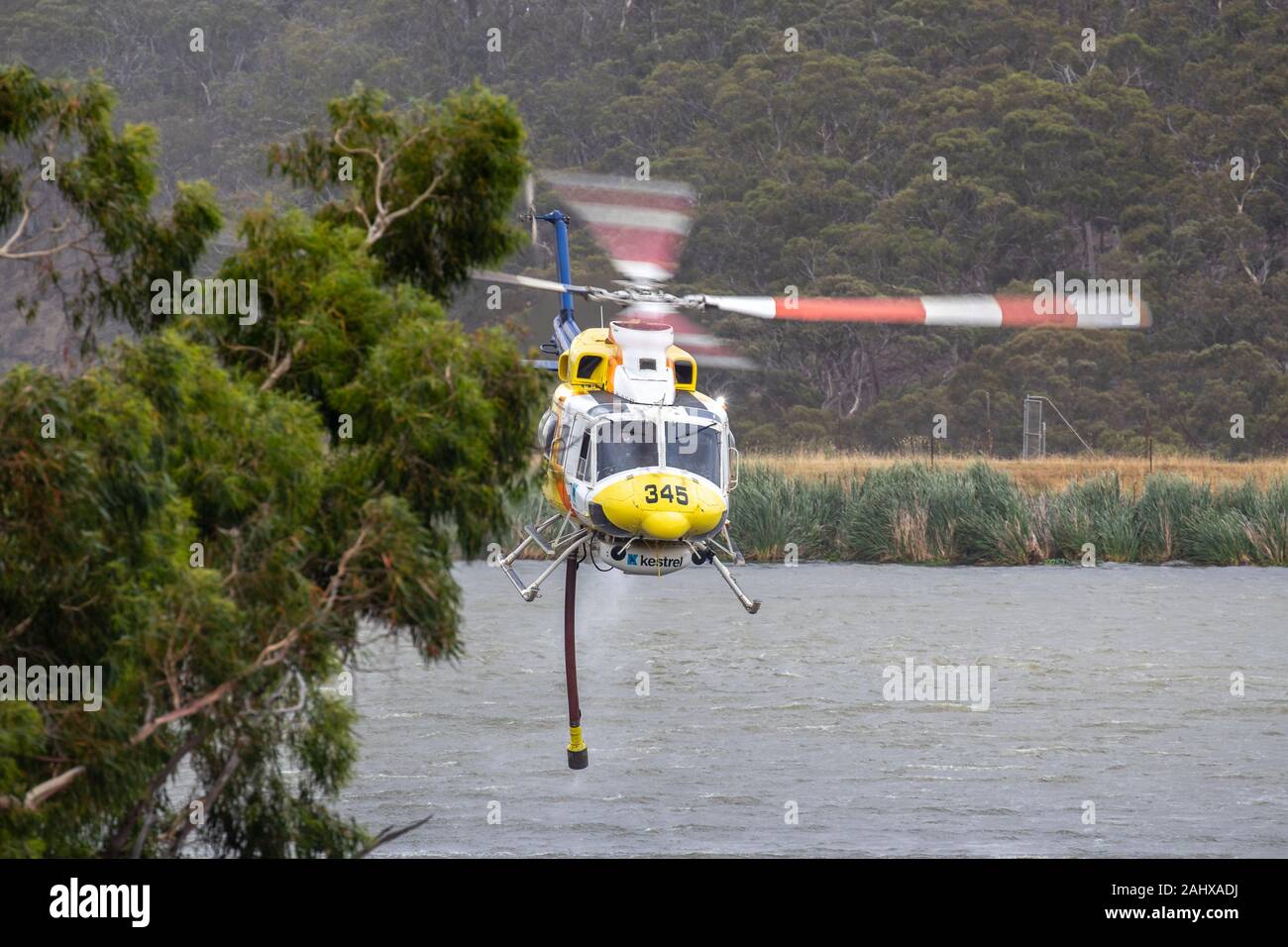 Bell 412 helicopter taking off after filling with a load of water to ...