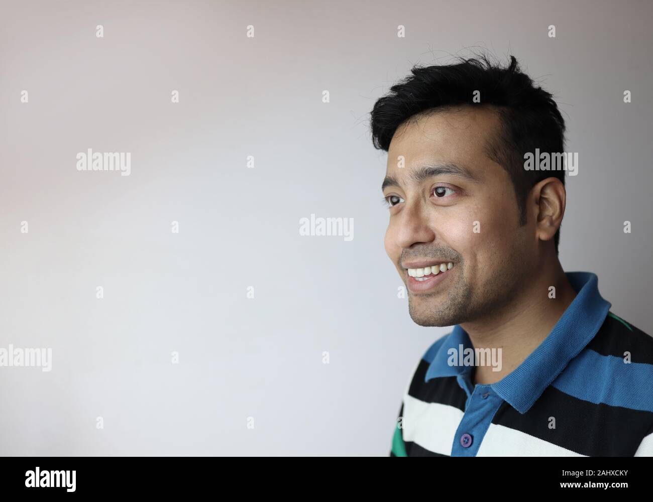 side face of an asian man smiling and looking towards a copy space with ...