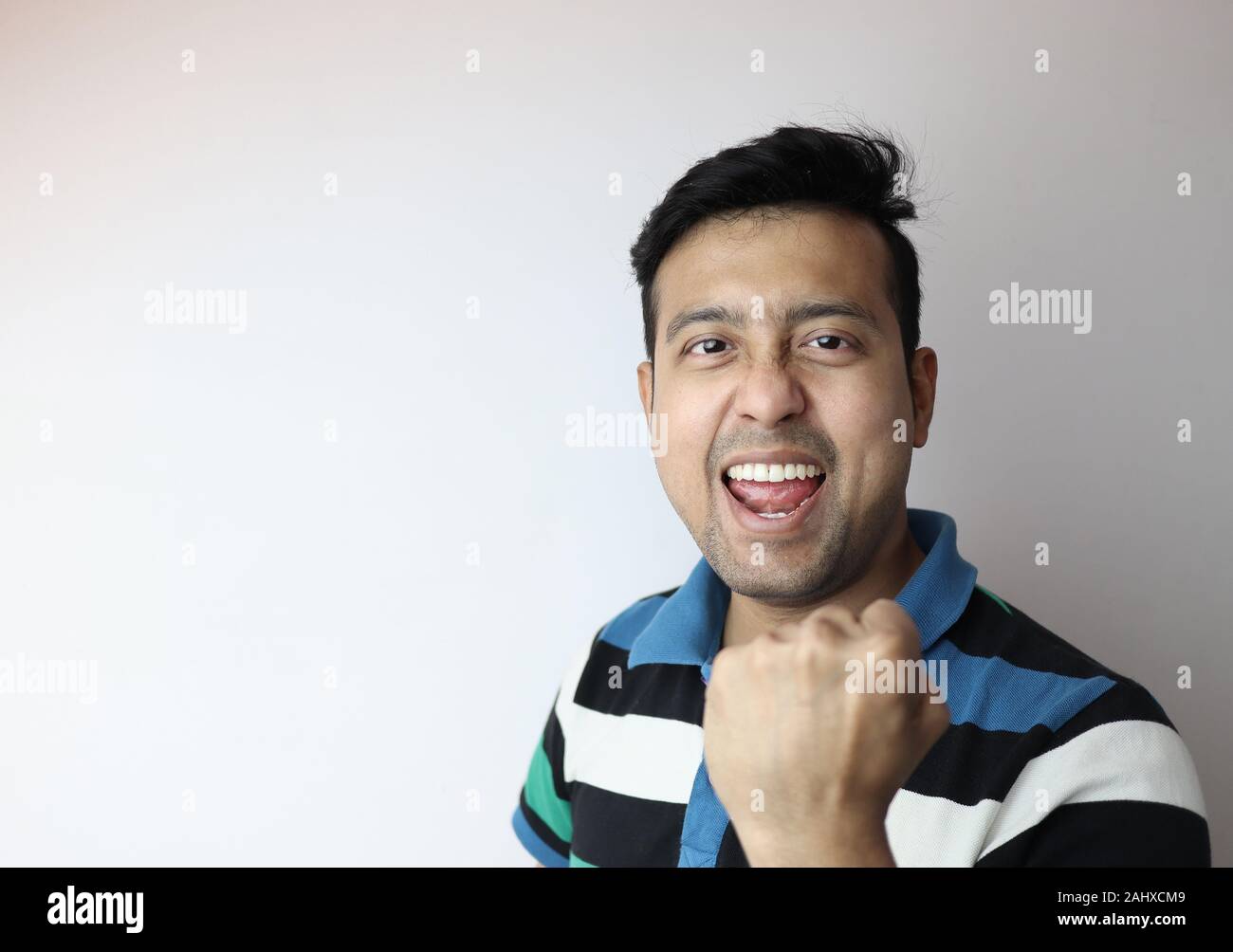 oh yeah. face of an asian man with clinched fist showing delighted ...