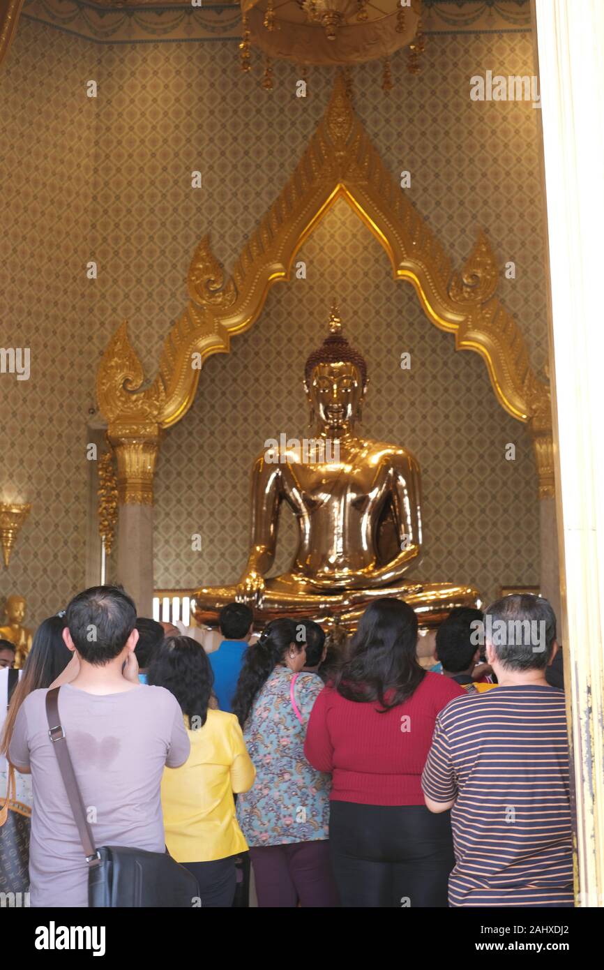 Visitors come to pay respect to a gold Buddha image Stock Photo - Alamy