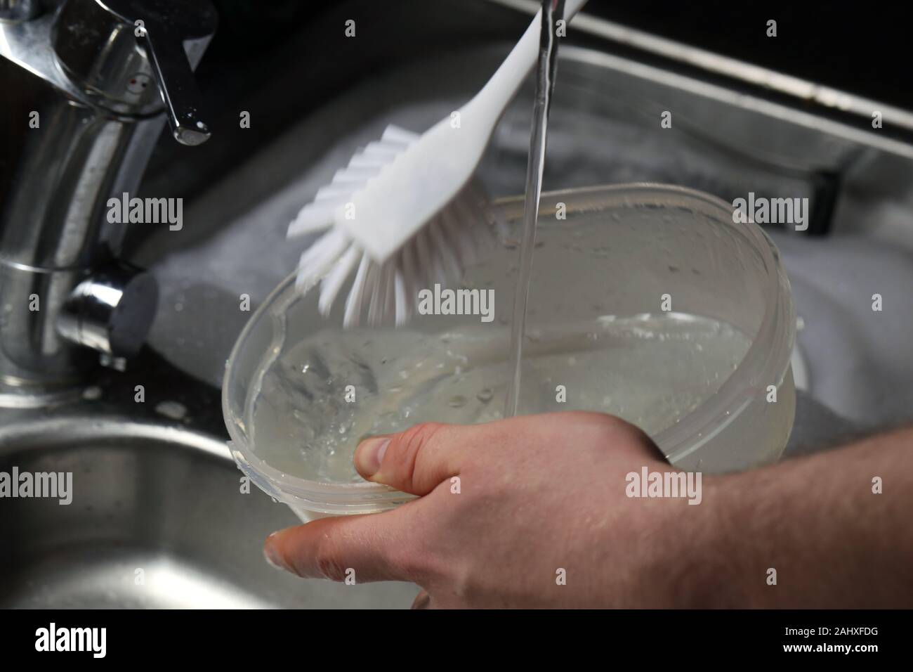 Doing dishes after cooking at home. Caucasian male doing the dishes ...
