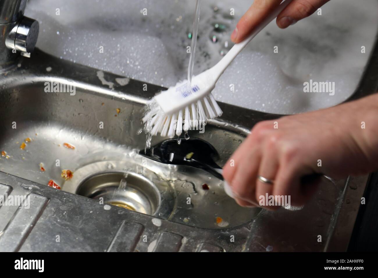 Doing dishes after cooking at home. Caucasian male doing the dishes ...