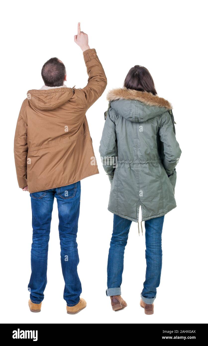 Back view of couple couple in winter jackets pointing. beautiful ...