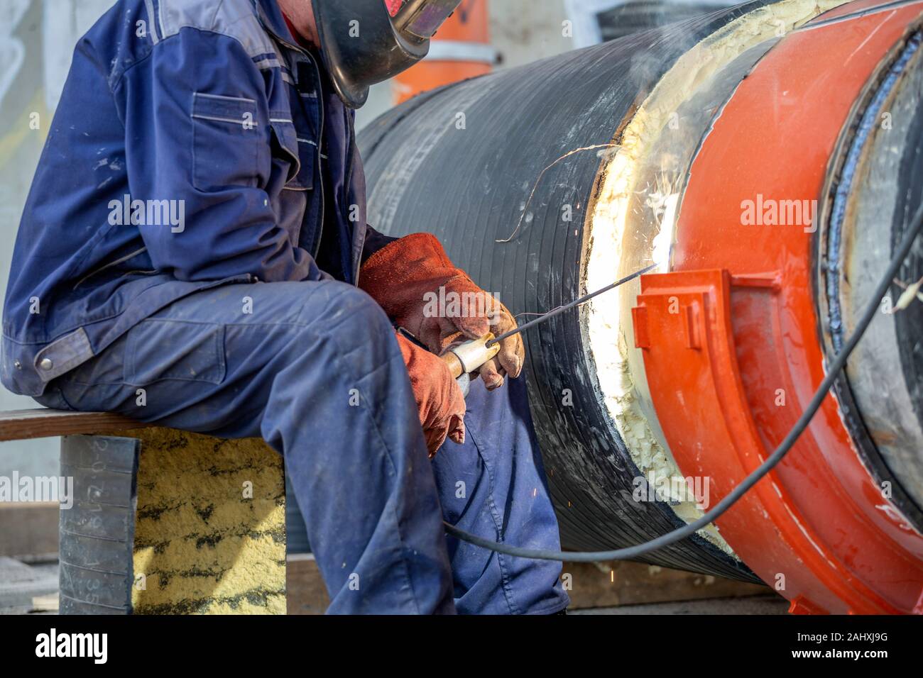Worker welding pipeline outdoors using arc welding at construction site ...