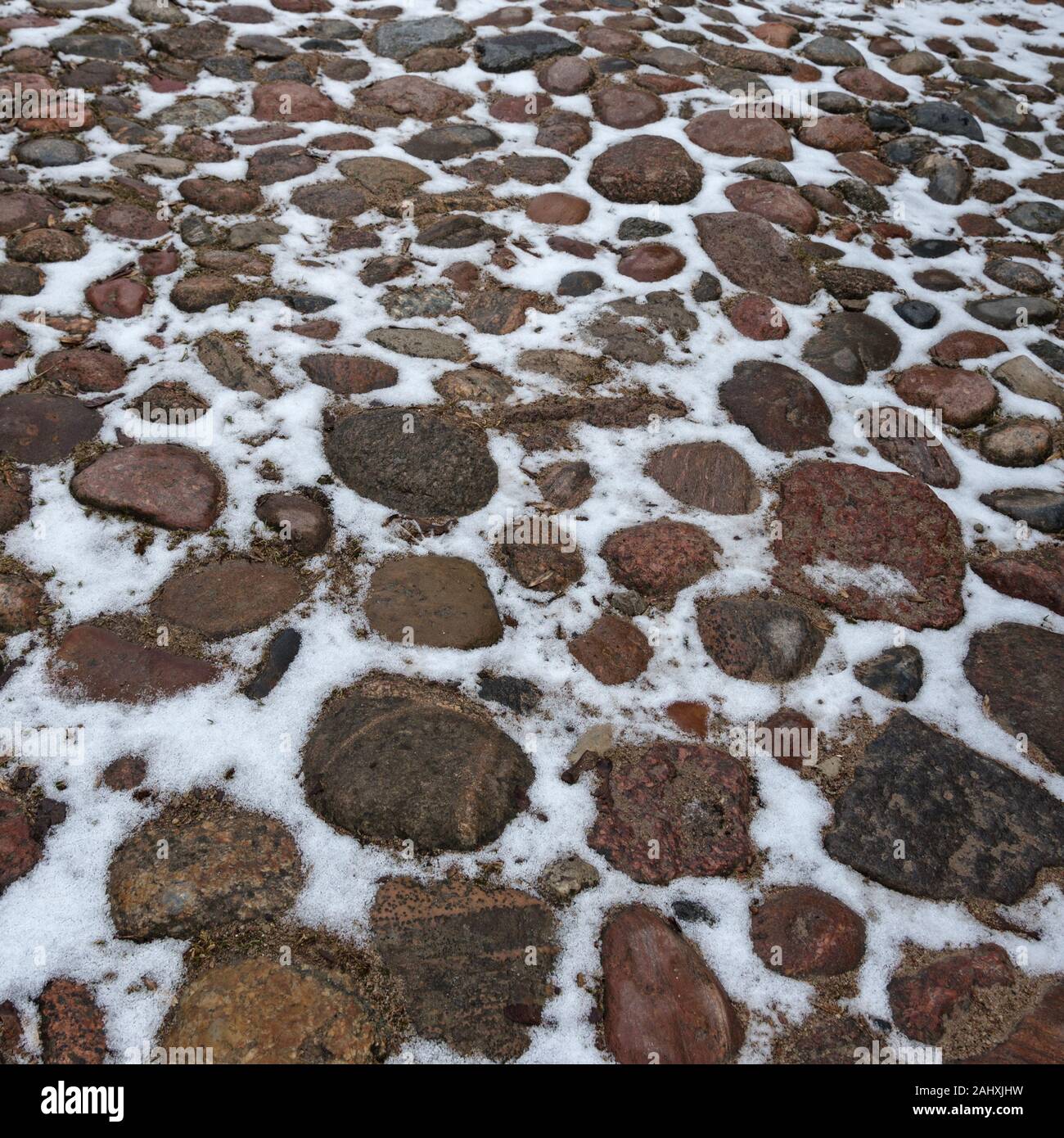 Old cobblestones road covered with snow Stock Photo - Alamy