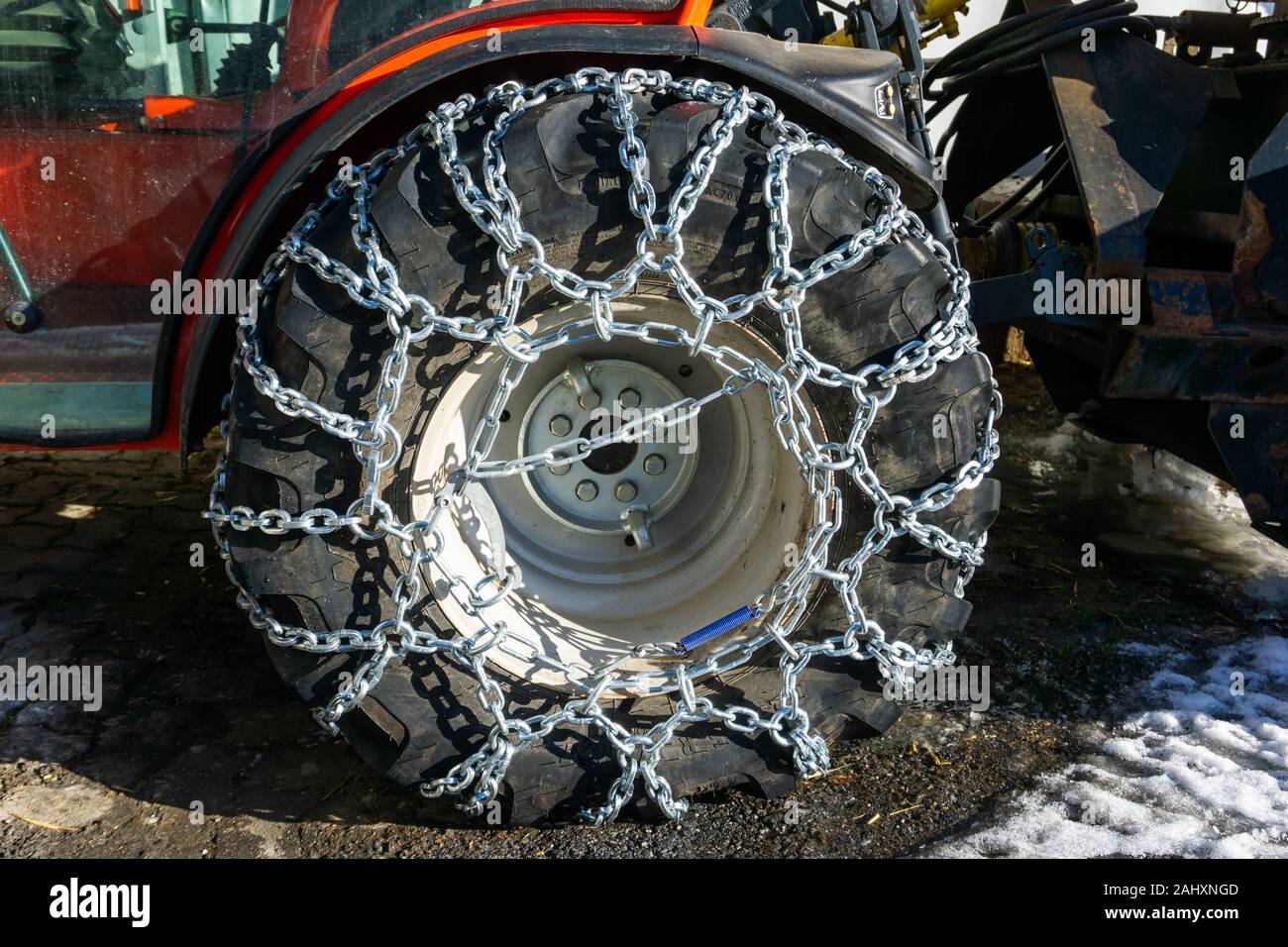 A close up view of heavy-duty snow chains mountain on tire of small ...