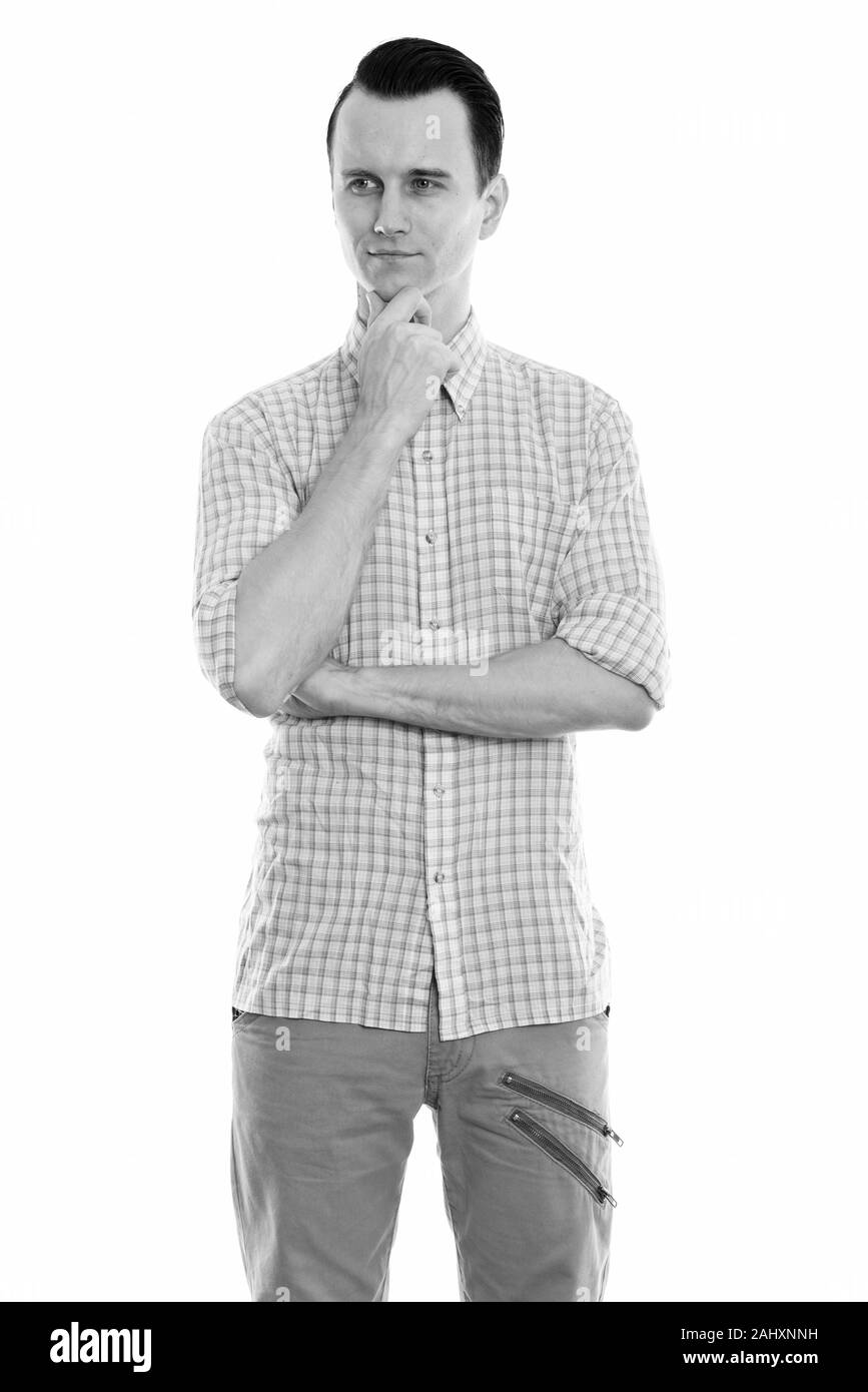Studio shot of young handsome man standing while thinking Stock Photo ...