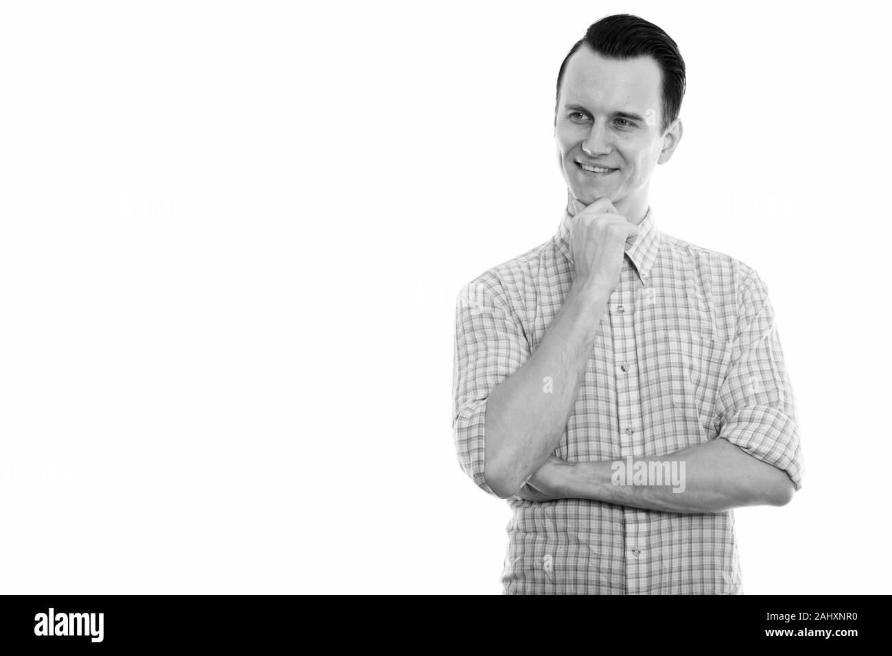 Studio shot of young happy man smiling and thinking Stock Photo - Alamy