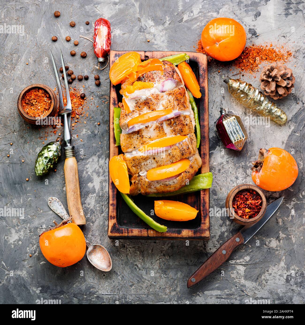 Roasted of pork with persimmon on a cutting board.Holiday food Stock ...