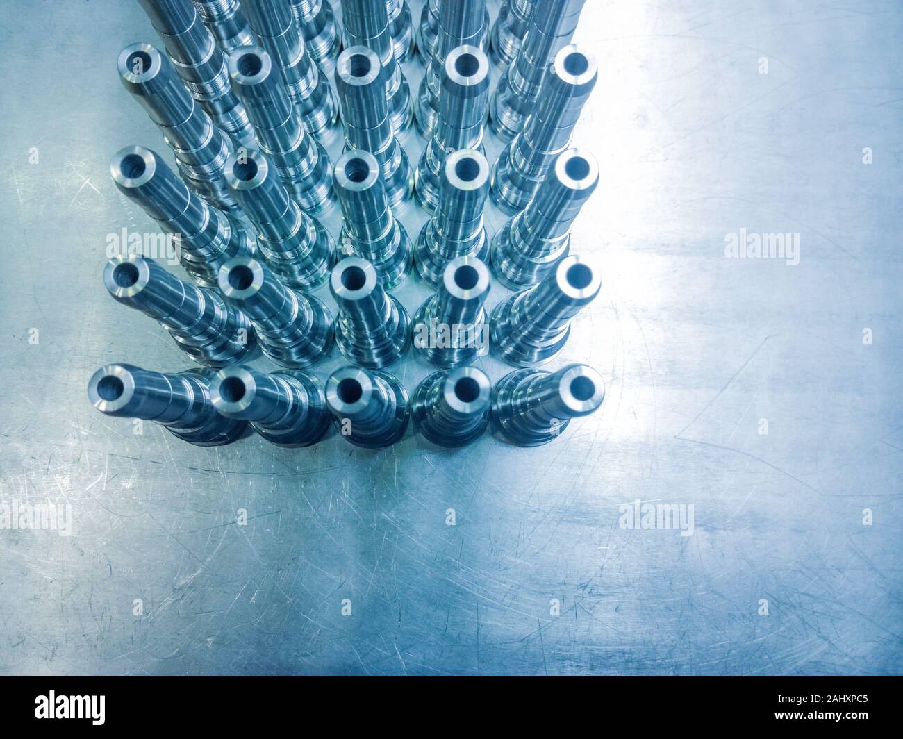 Shiny blue steel parts background, long clean steel rods after fine cnc ...