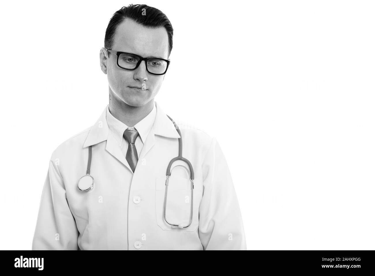 Studio shot of young sad man doctor thinking while looking down Stock ...