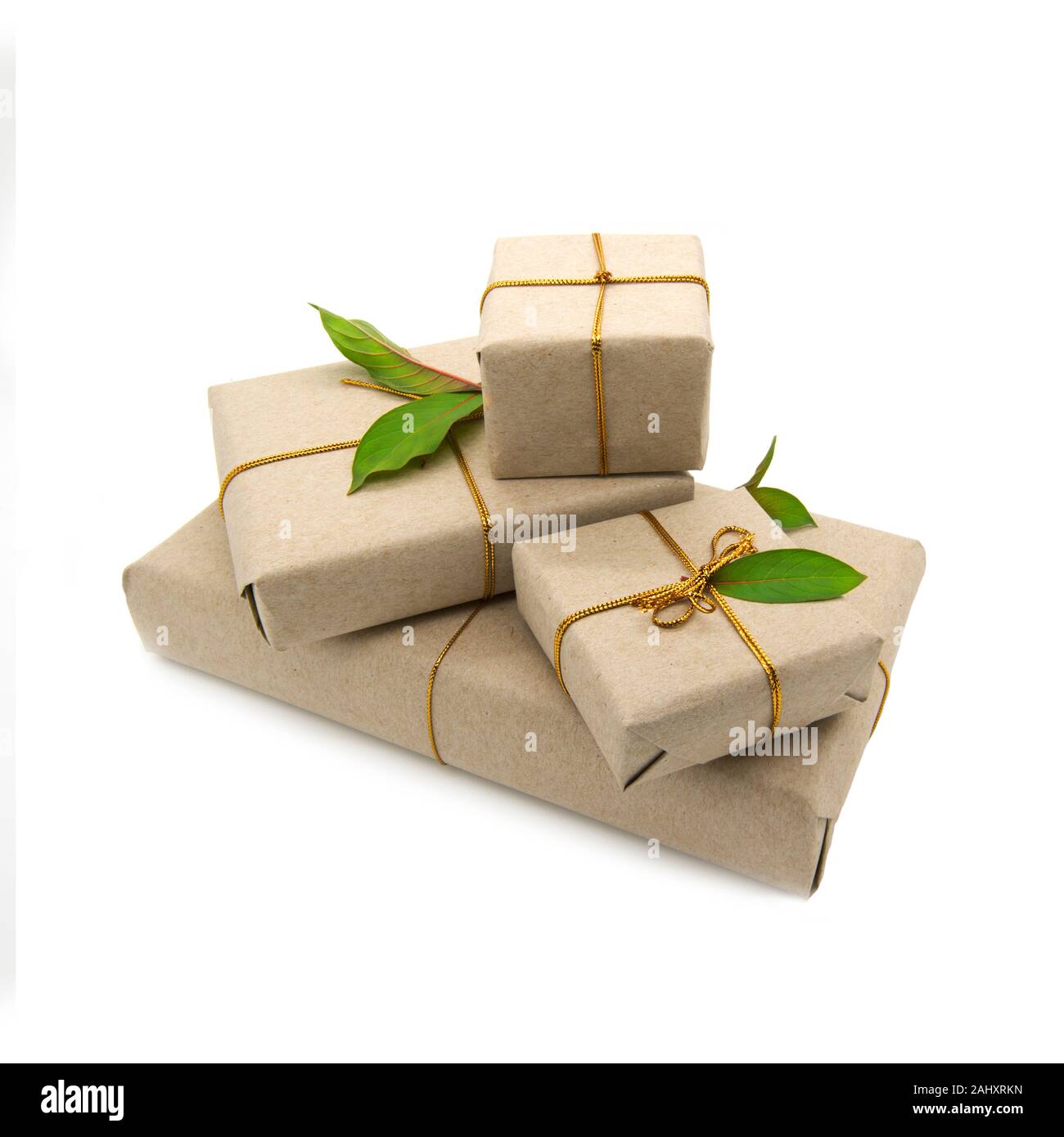 Four boxes packed in brown paper with natural leaves Stock Photo - Alamy