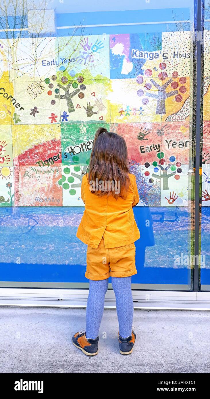 A baby gil admiring a contemporary art wall painting Stock Photo - Alamy
