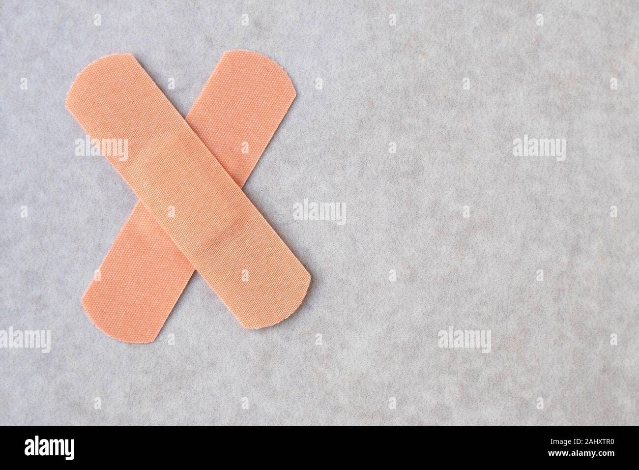 A two medical plasters of cross shape on neutral background. Patches ...