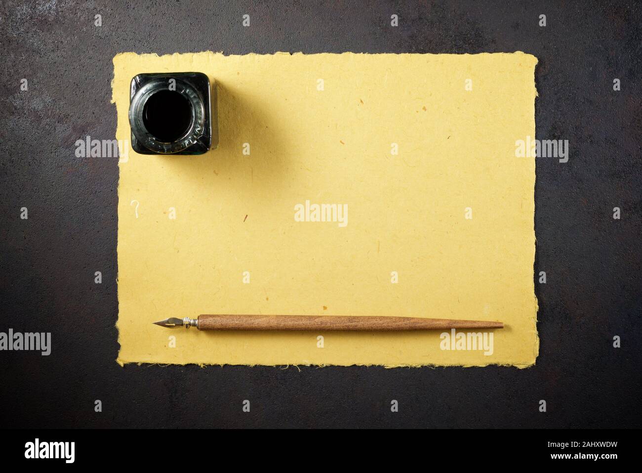 Nib pen for calligraphy and inkwell on a table Stock Photo - Alamy