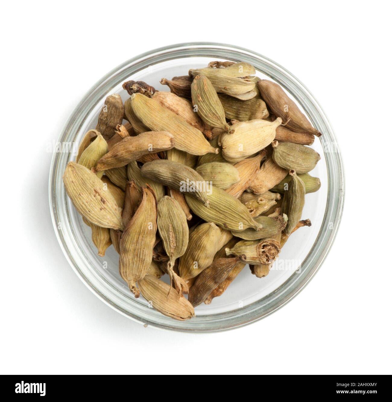 Dried cardamon in a bowl on white background Stock Photo - Alamy