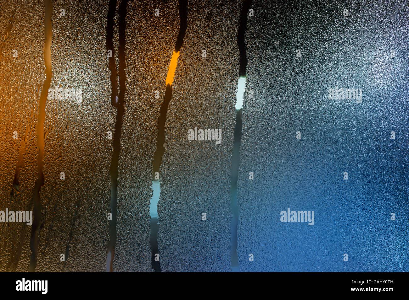 an abstract background of night wet window glass with smudges in teal ...