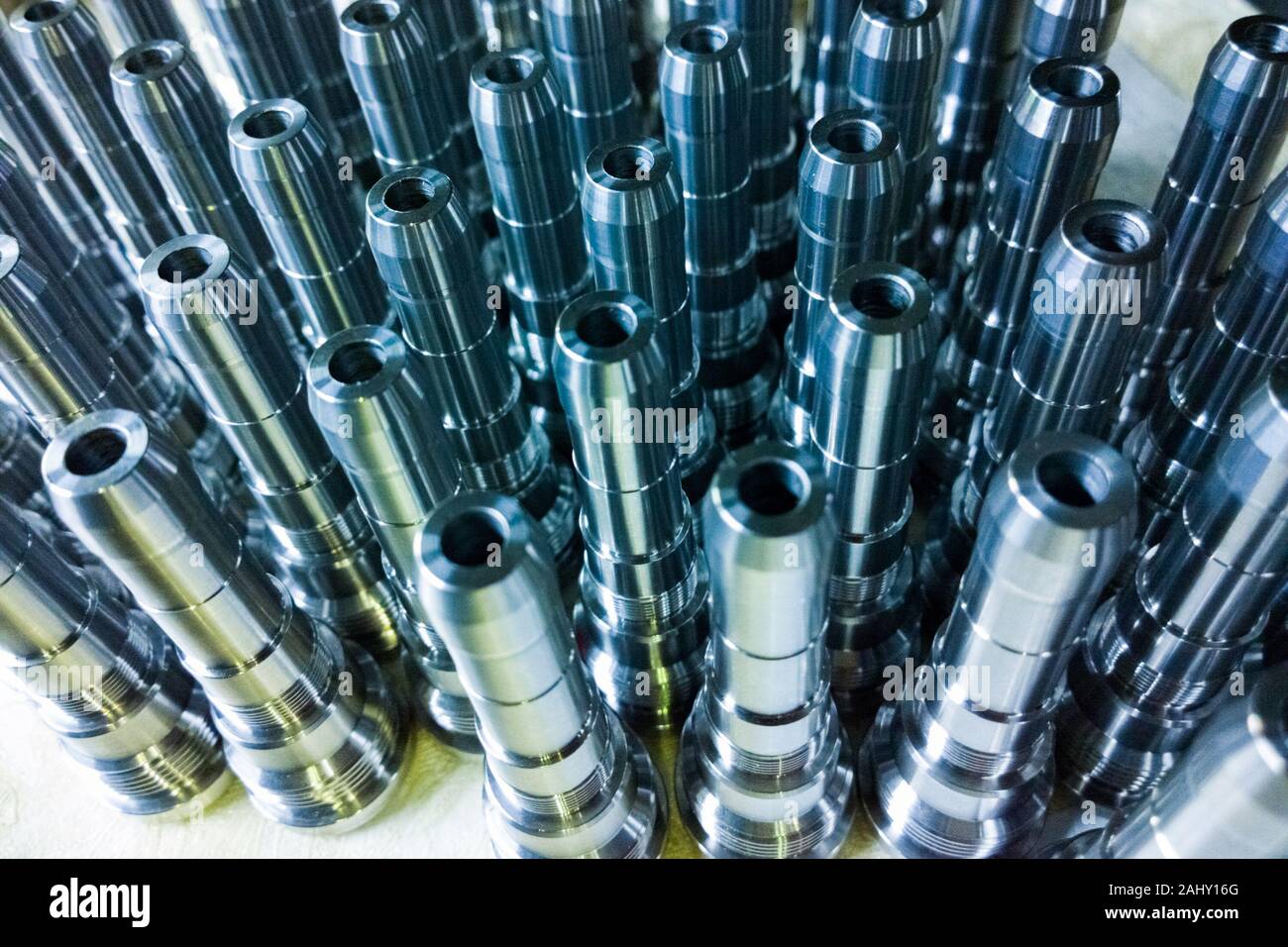 Shiny blue steel parts background, long clean steel threaded rods after ...