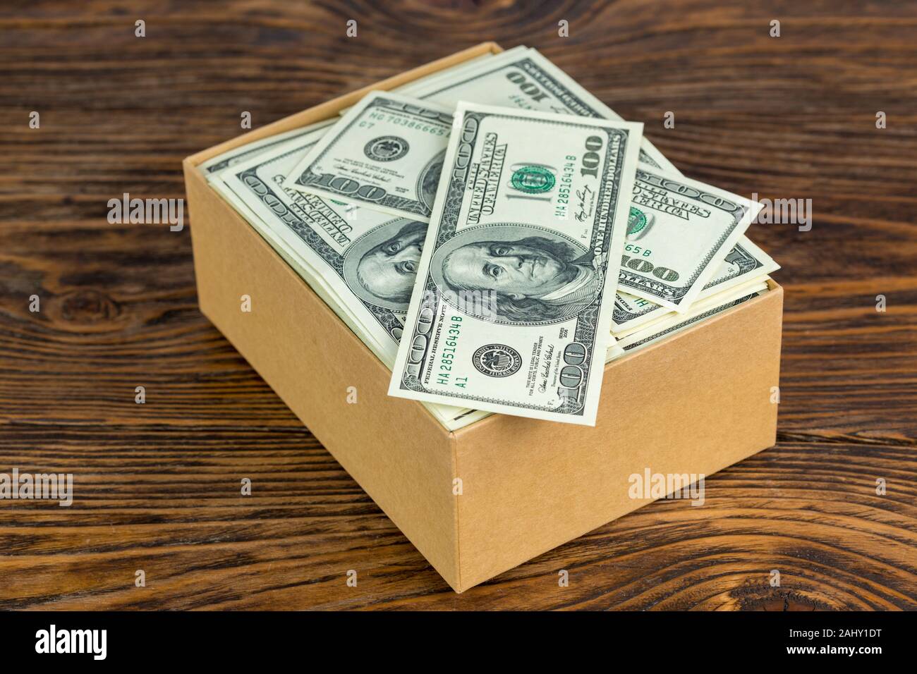 small cardboard box full of hundred dollar banknotes close-up with ...