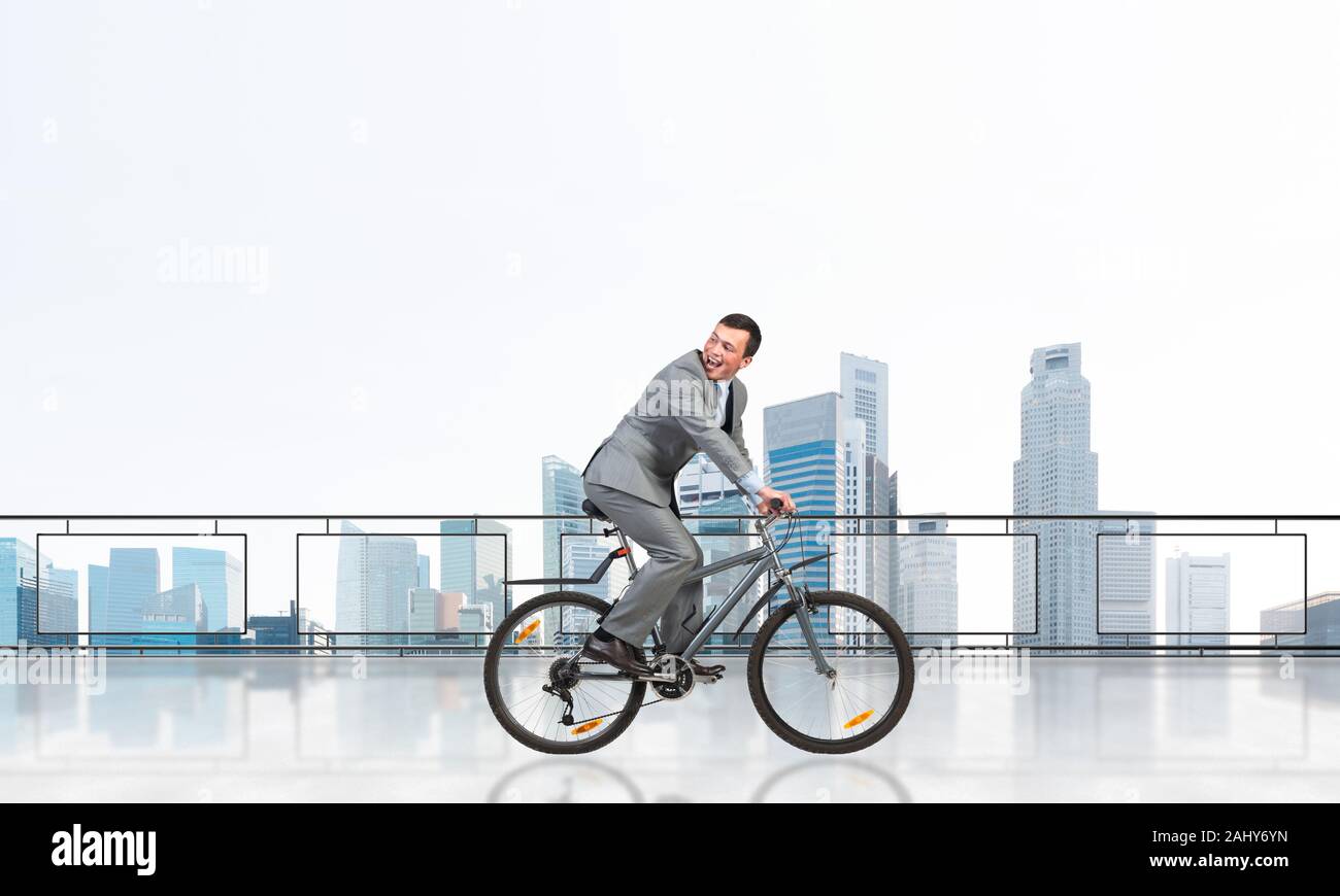 Man wearing business suit riding bicycle on penthouse balcony. Handsome ...