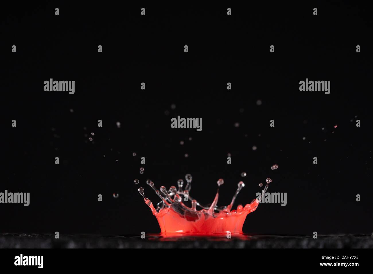 Red liquid ink splash on black background Stock Photo - Alamy